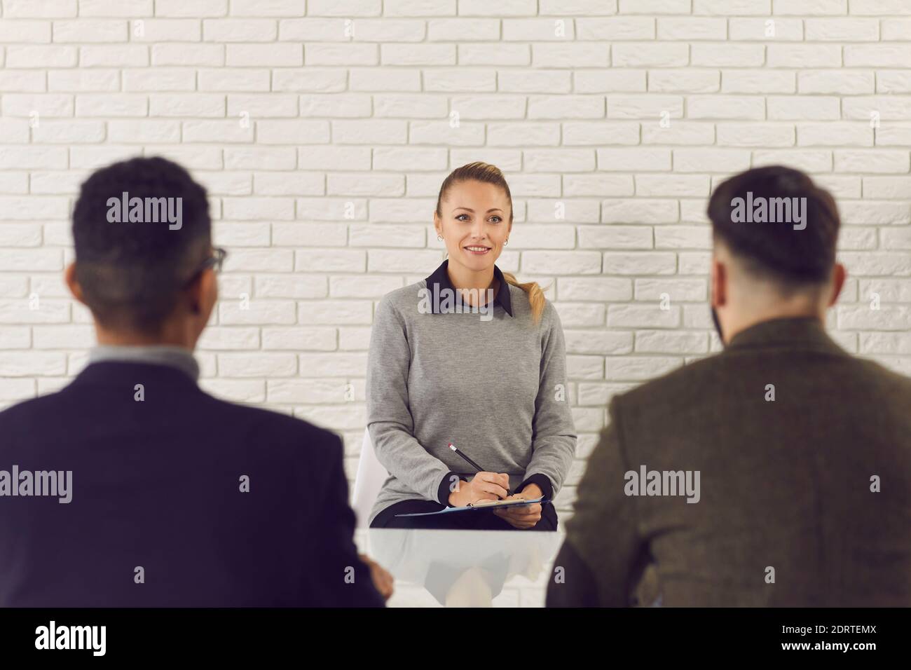 Female recruiting specialist sitting and listening to presentation of ...