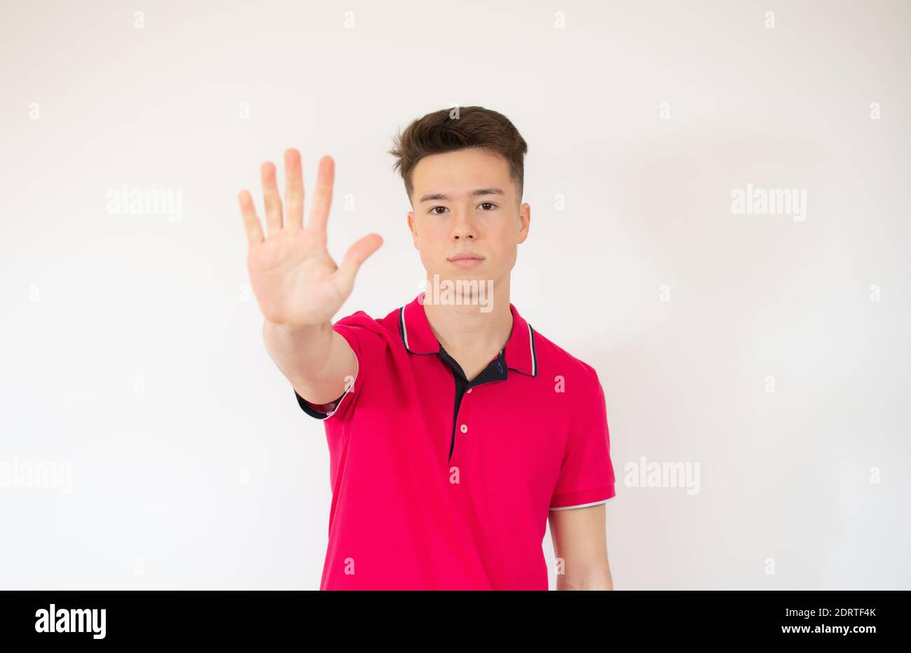 Teen boy doing stop sign with palm of hands, on white background ...