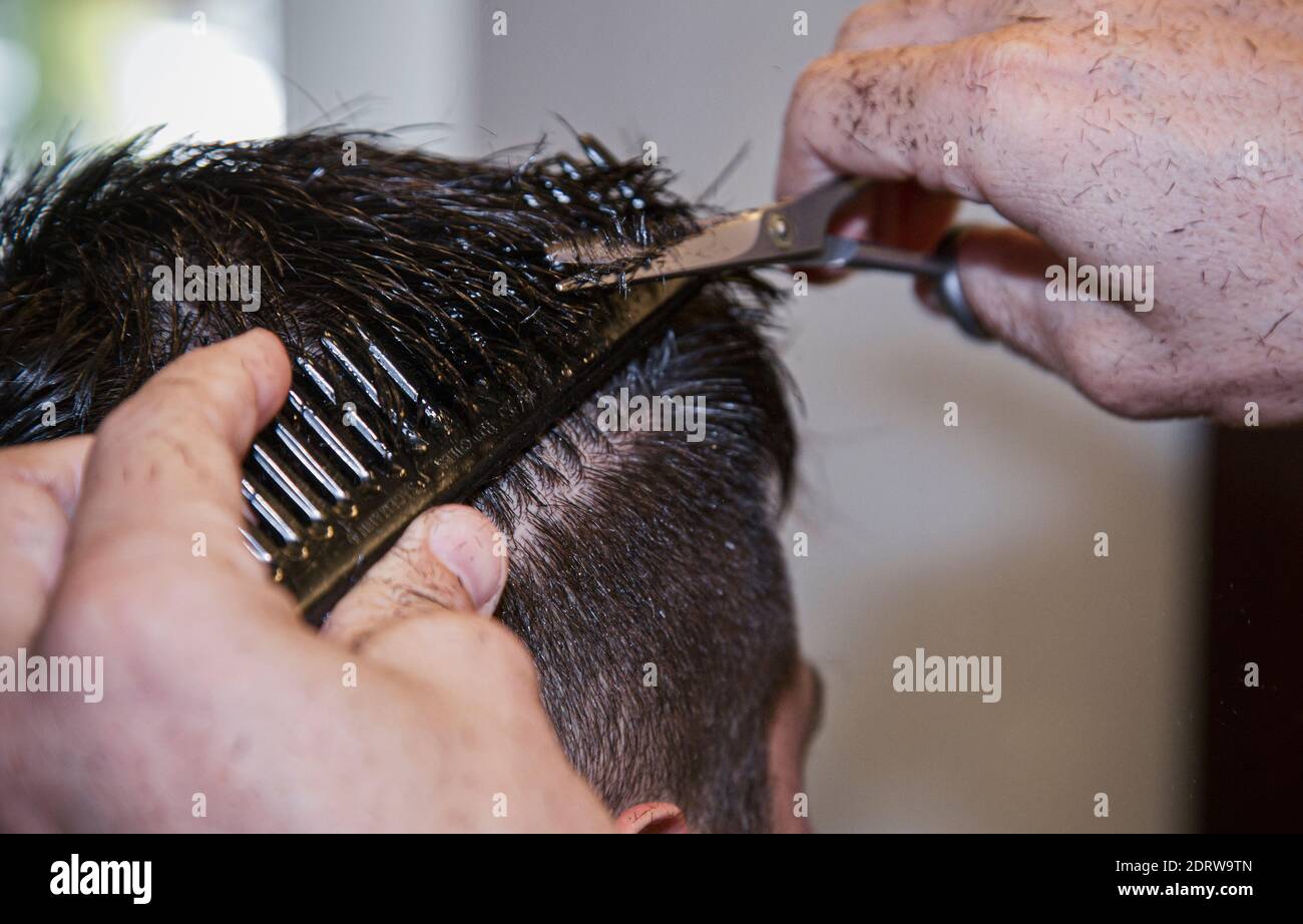 Cut and combine. Close-up photo of a man having his hair cut with a ...