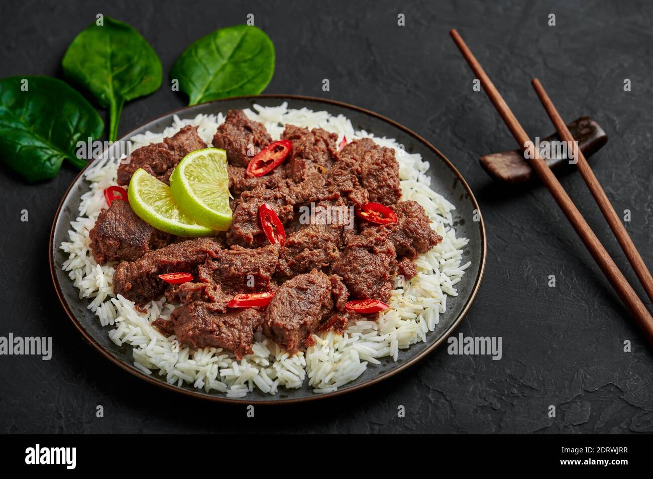 Beef Rendang on black plate at black slate table top. Indonesian padang ...