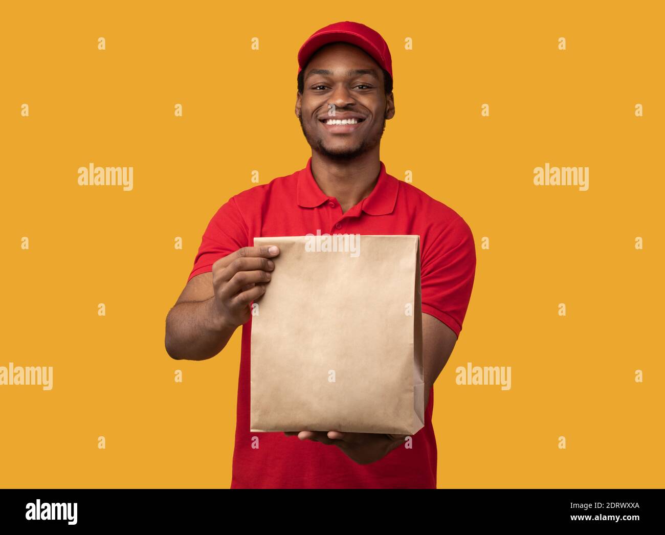 Happy smiling black delivery man holding package Stock Photo - Alamy