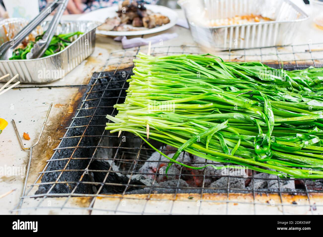 Green Chinese chives vegetable on the charcoal stove for barbecue Stock ...