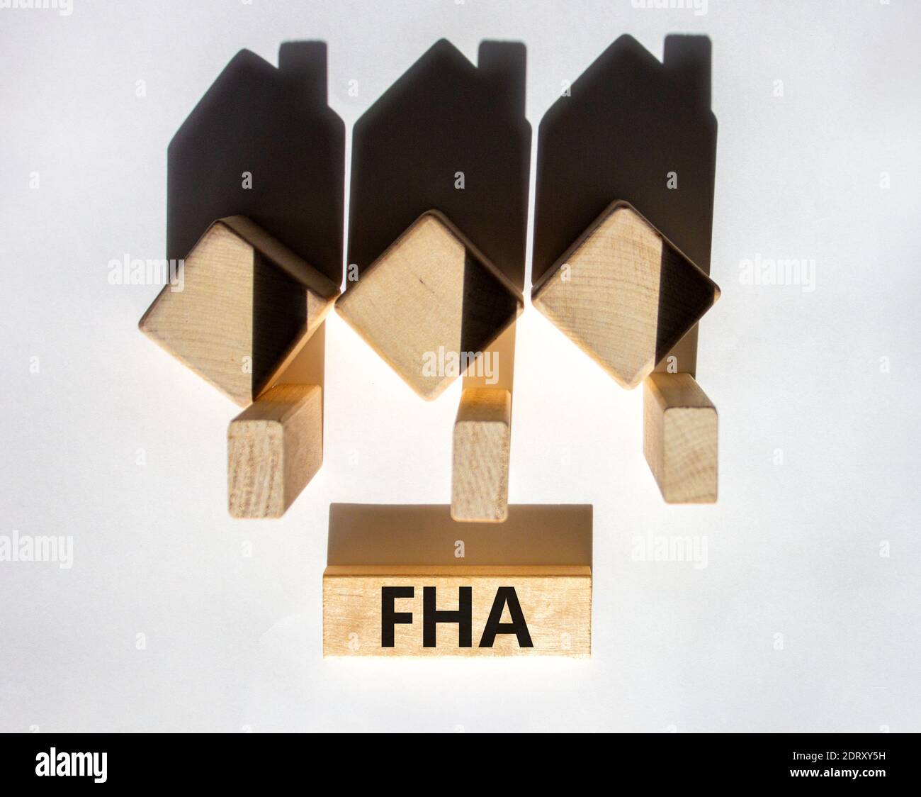 FHA symbol. Houses created by shadows from wooden cubes. The word 'FHA ...