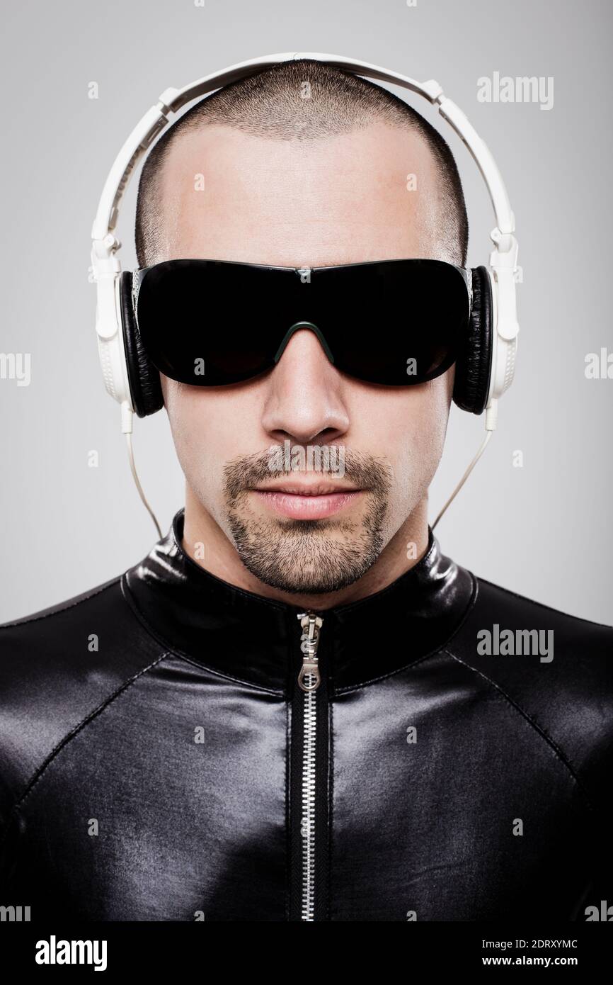 Portrait of futuristic man listening to music with headphones over ...