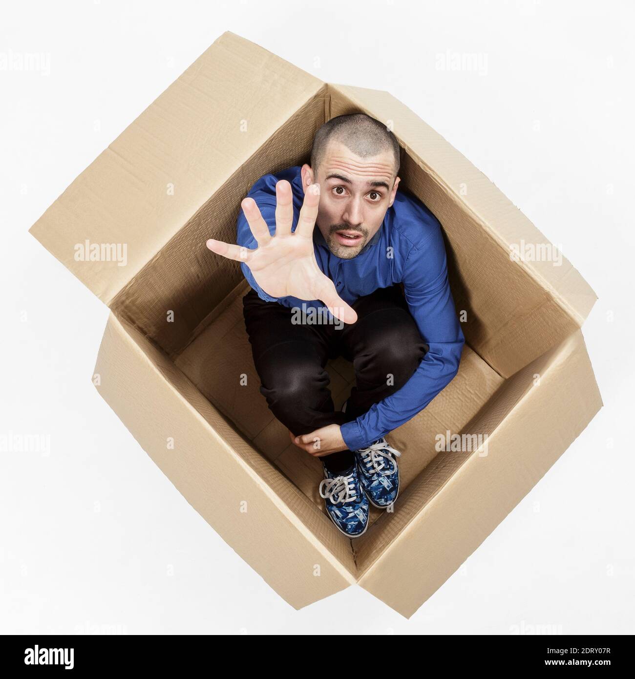 Man in a cardboard box on a white background Stock Photo - Alamy
