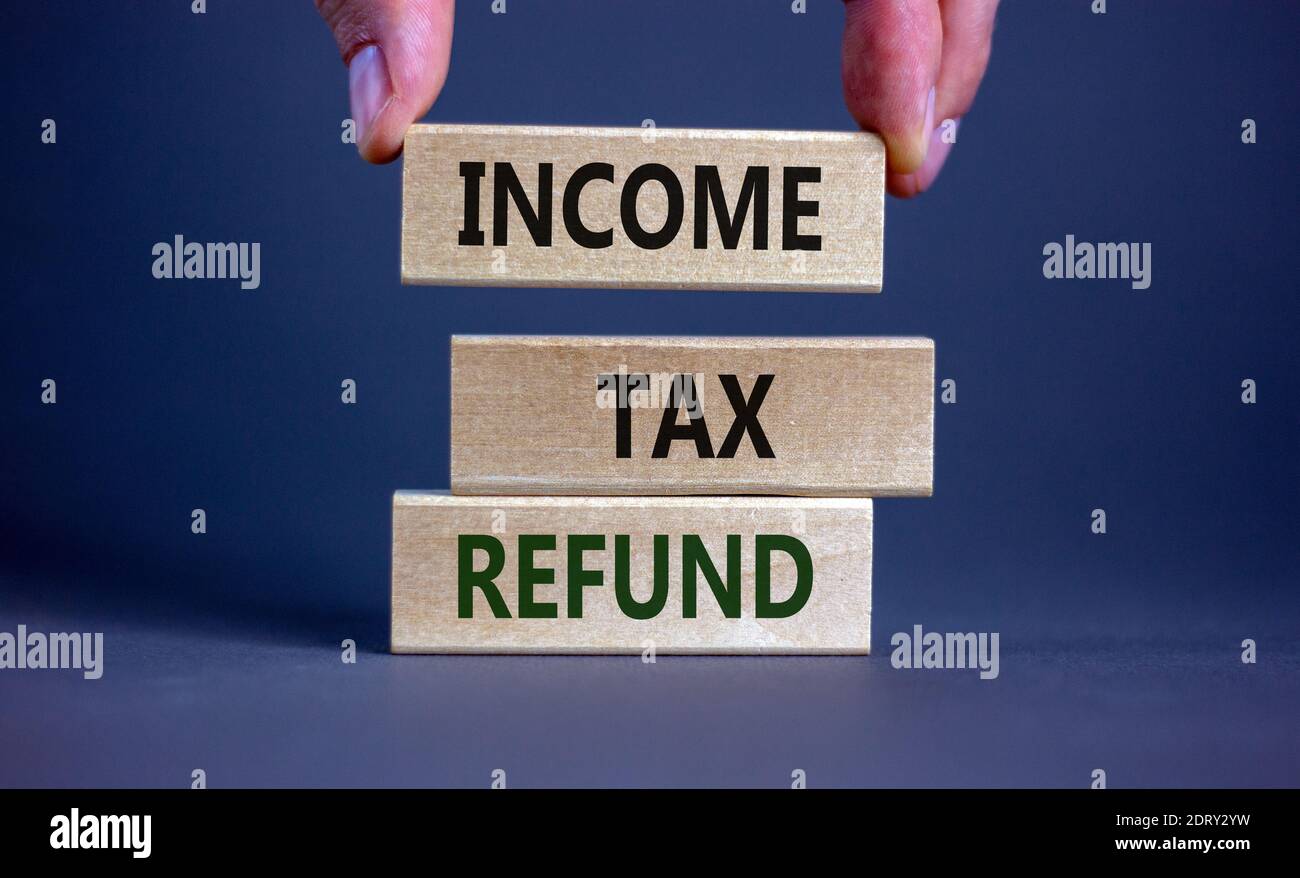 Income tax refund symbol. Wooden blocks form the words 'Income tax ...