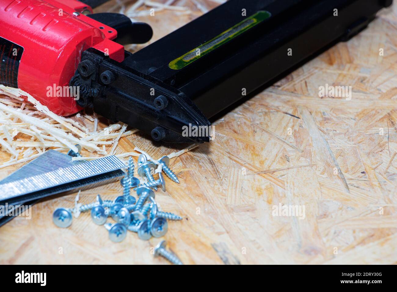 Red pneumatic construction stapler and a stack of staples for the ...