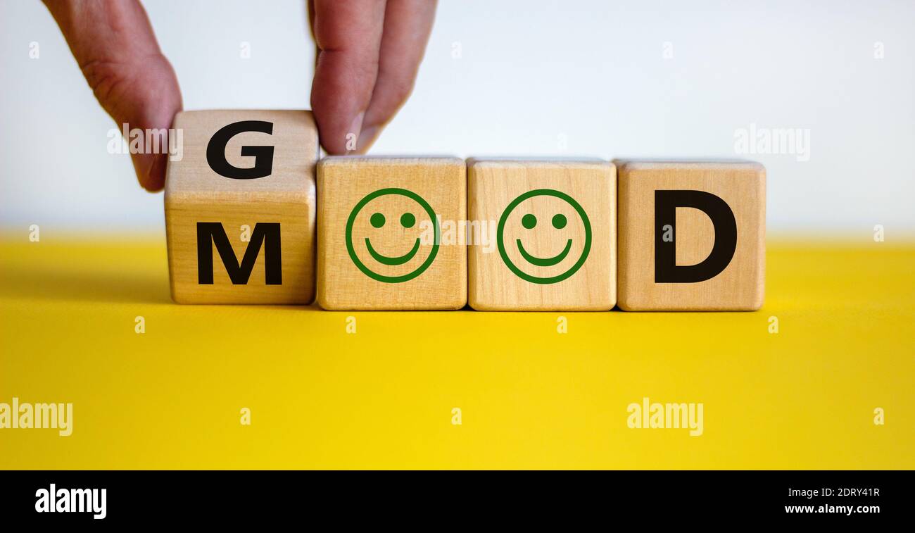 Good mood symbol. Male hand flips a wooden cube and changes the word ...