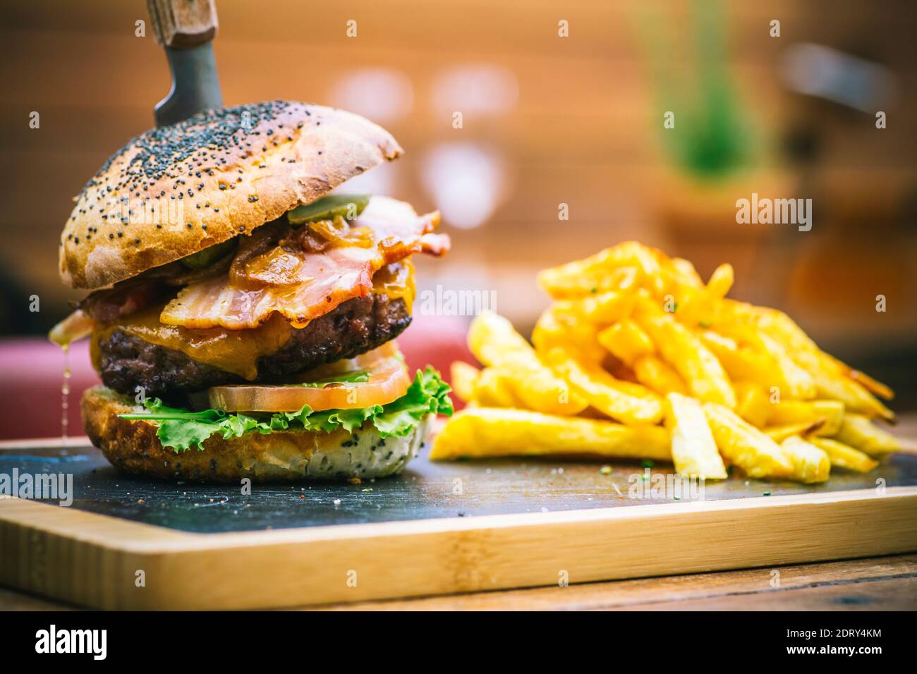 Traditional plate of chips and burger with glass on rustic table Stock ...