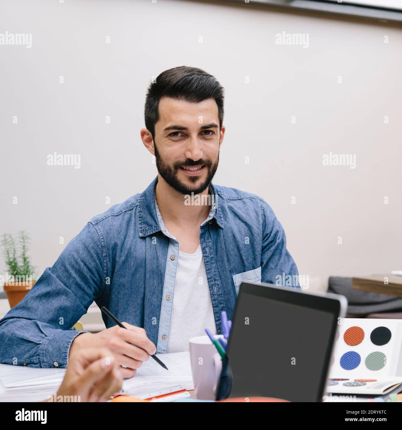 Young man preparing a new decoration project in a coworking espace ...