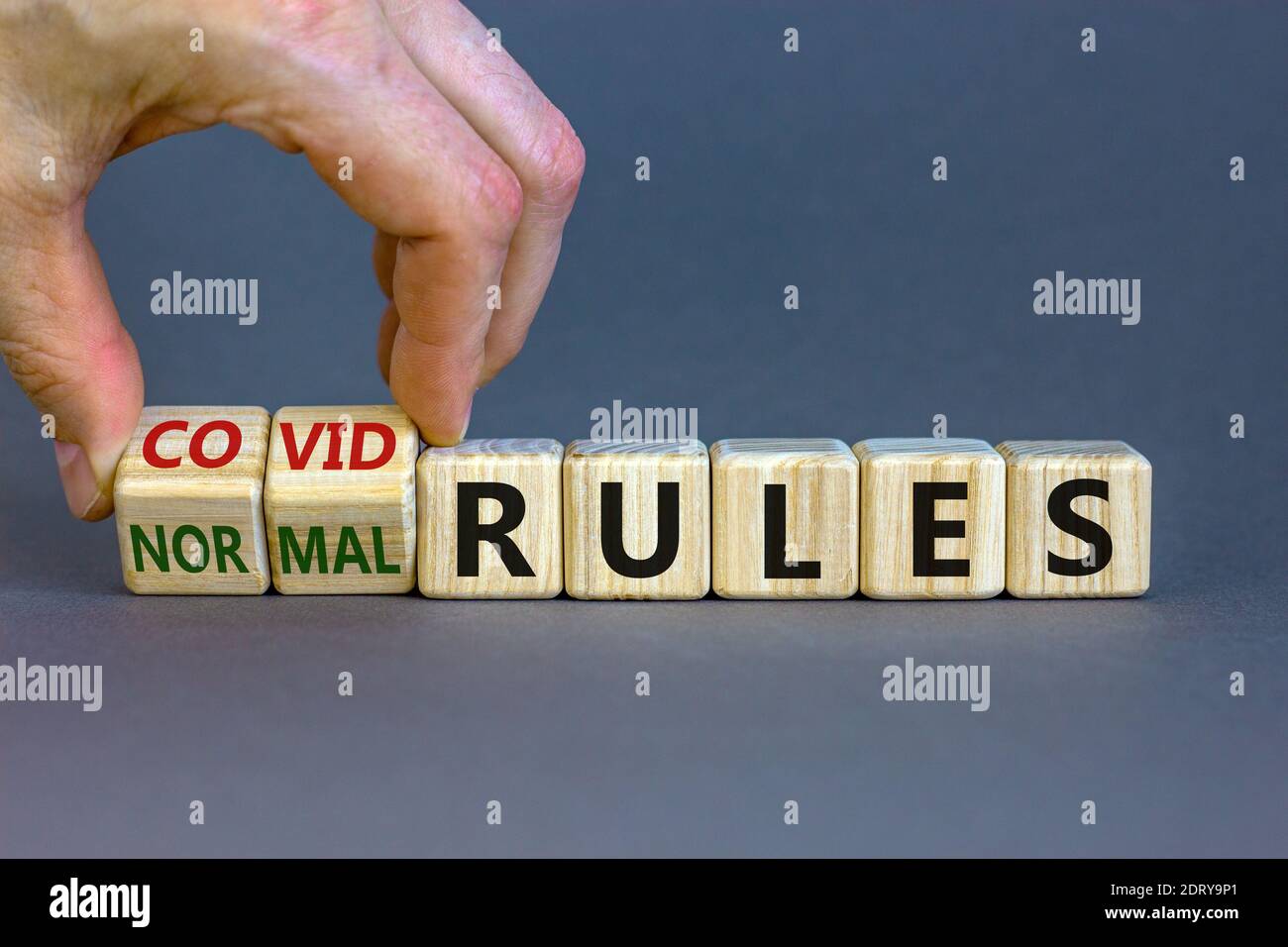 Covid rules symbol. Hand turns cubes and changes words 'covid rules' to ...