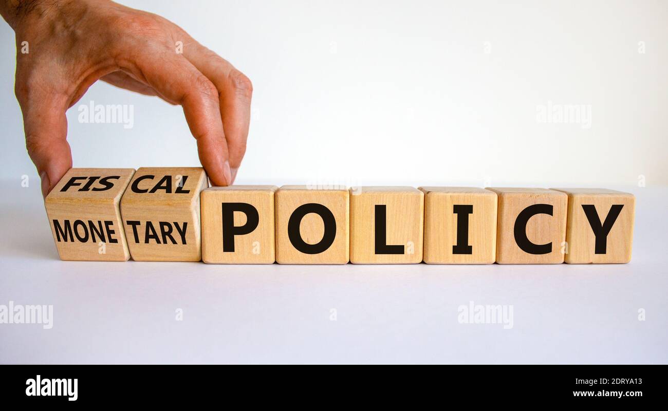 Fiscal or monetary policy symbol. Hand turns cubes and changes words ...