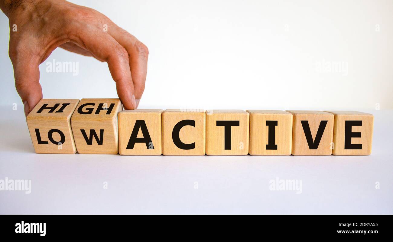 High or low active symbol. Businessman hand turns cubes and changes the ...