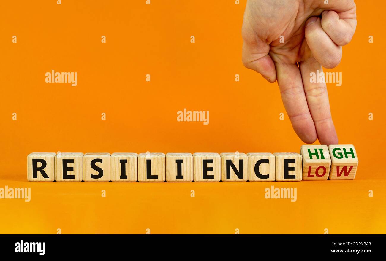 High or low resilience symbol. Male hand flips wooden cubes and changes ...