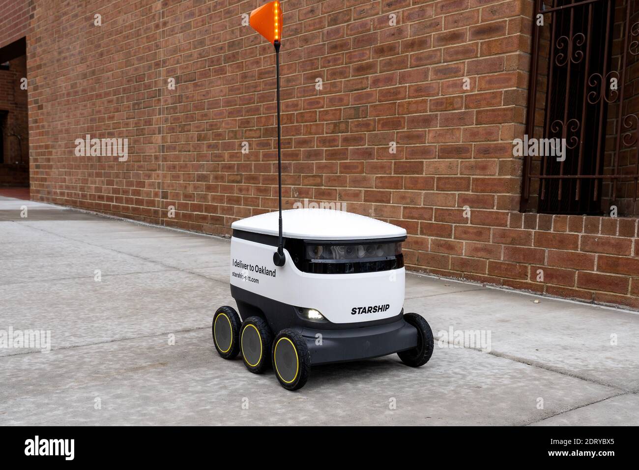 A Starship food delivery robot is driving on the sidewalk in University ...