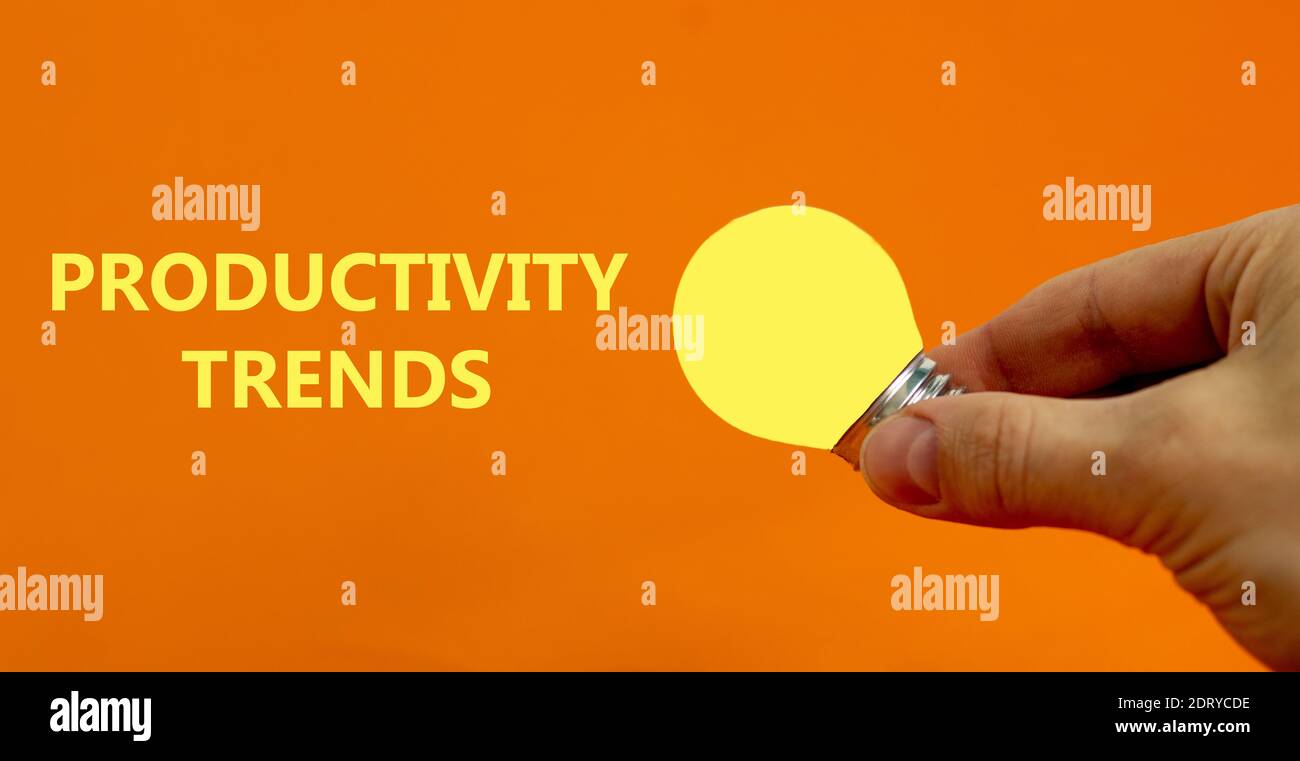 Productivity trends symbol. Businessman hand holding light bulb. Words ...