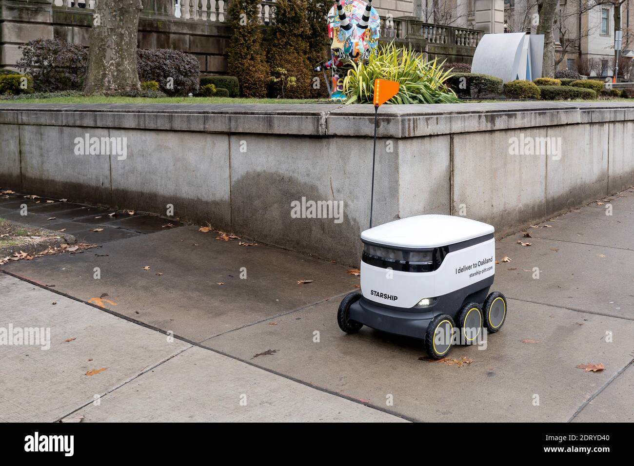 A Starship food delivery robot is driving on the sidewalk in University ...