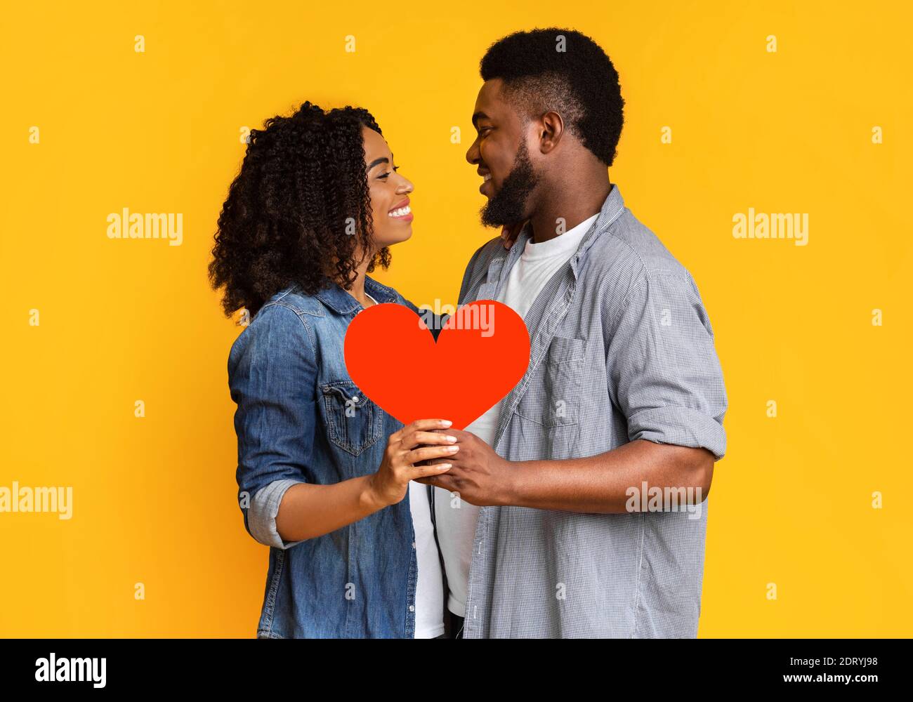 Cheerful Romantic Black Couple Embracing And Holding Red Paper Heart ...