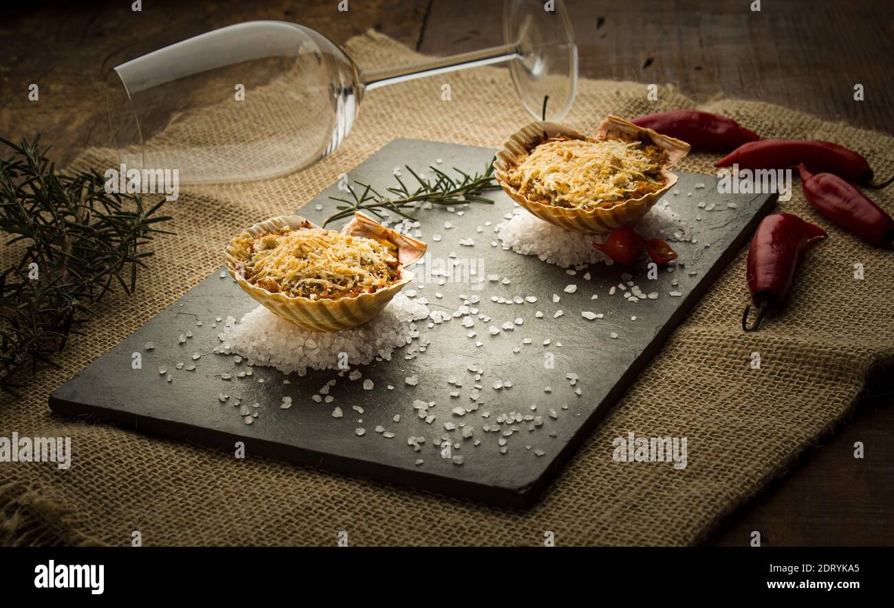 Shells stuffed with shredded meat and grated cheese, rustic background ...