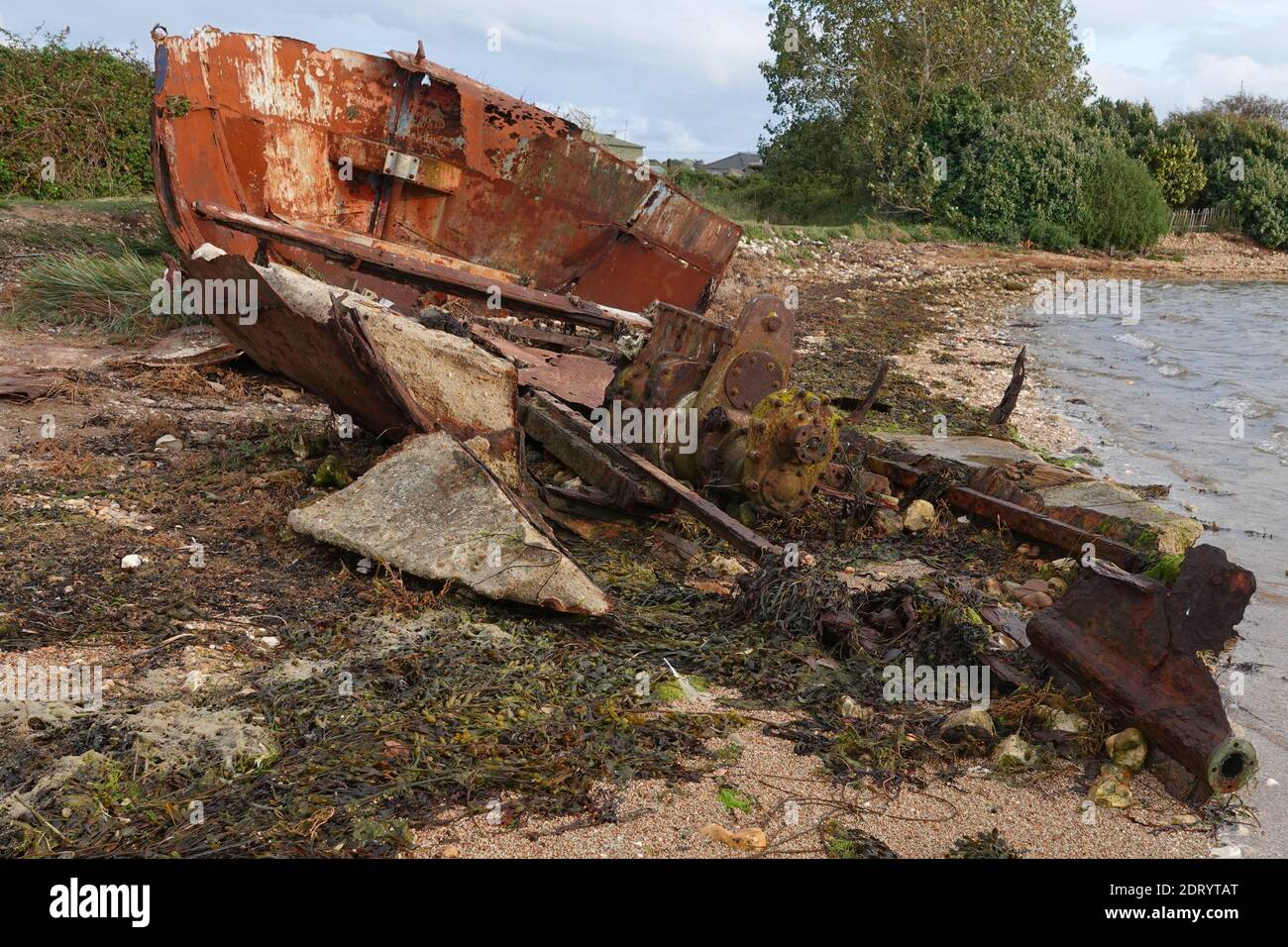 A rusting old hulk of a boat lying on the shore Stock Photo - Alamy