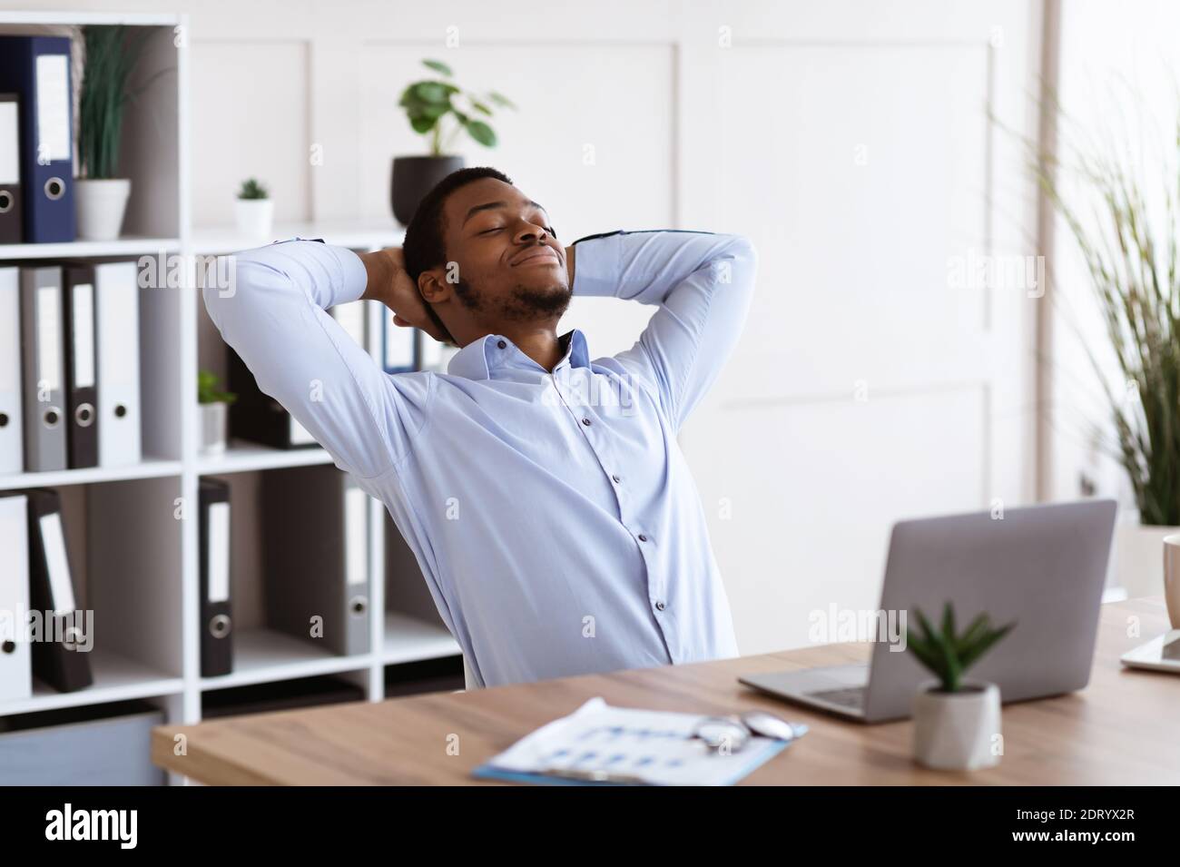 Relaxed african american manager resting on his chair Stock Photo - Alamy