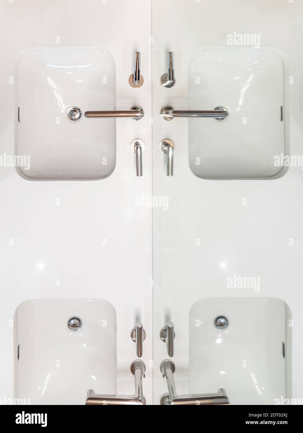Two bathrooms sinks with reflections in a mirror Stock Photo - Alamy