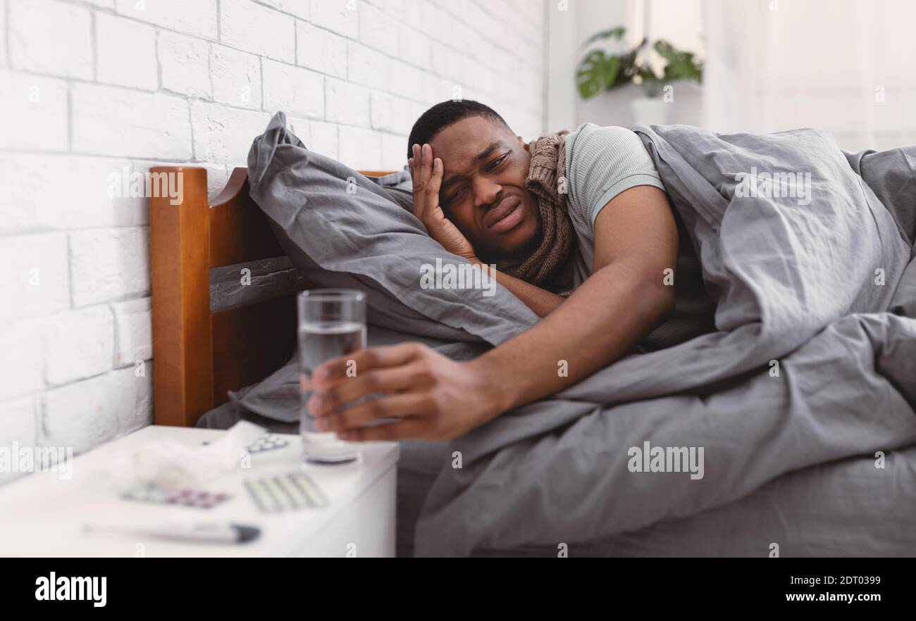 African Guy Taking Medication Having Fever Lying In Bed Indoor Stock ...