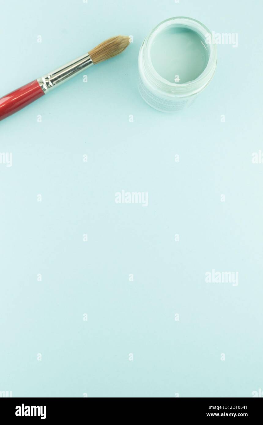 A vertical top view of a paintbrush and empty container isolated on ...