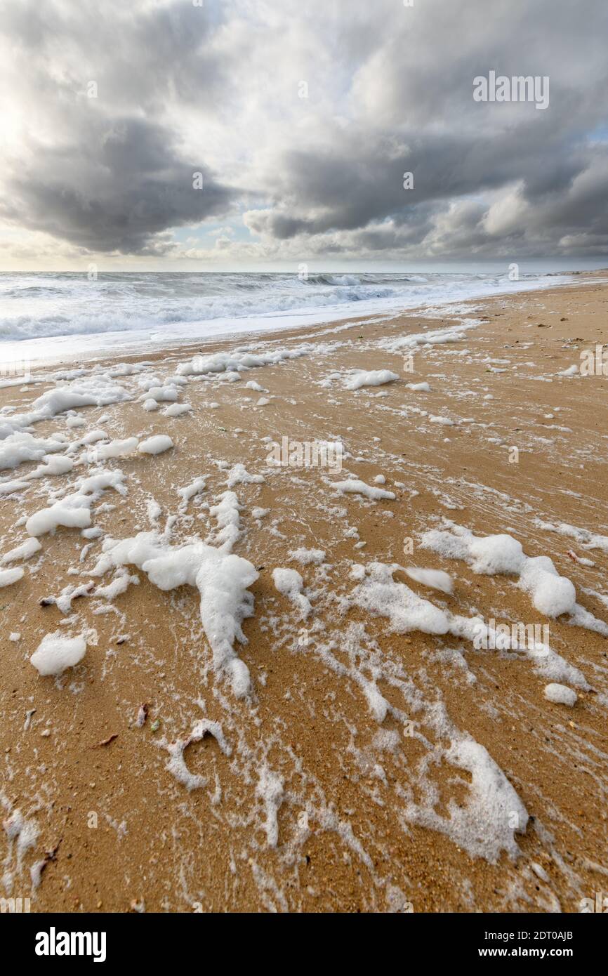 Windswept sea foam on a beach in the Atlantic Ocean near Olonne sur mer ...