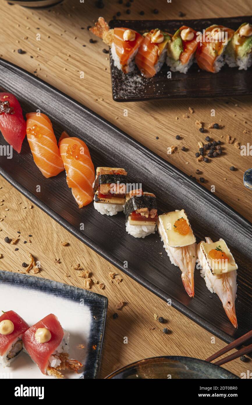 A vertical shot of a variety of sushi and nigiri on wooden table with ...