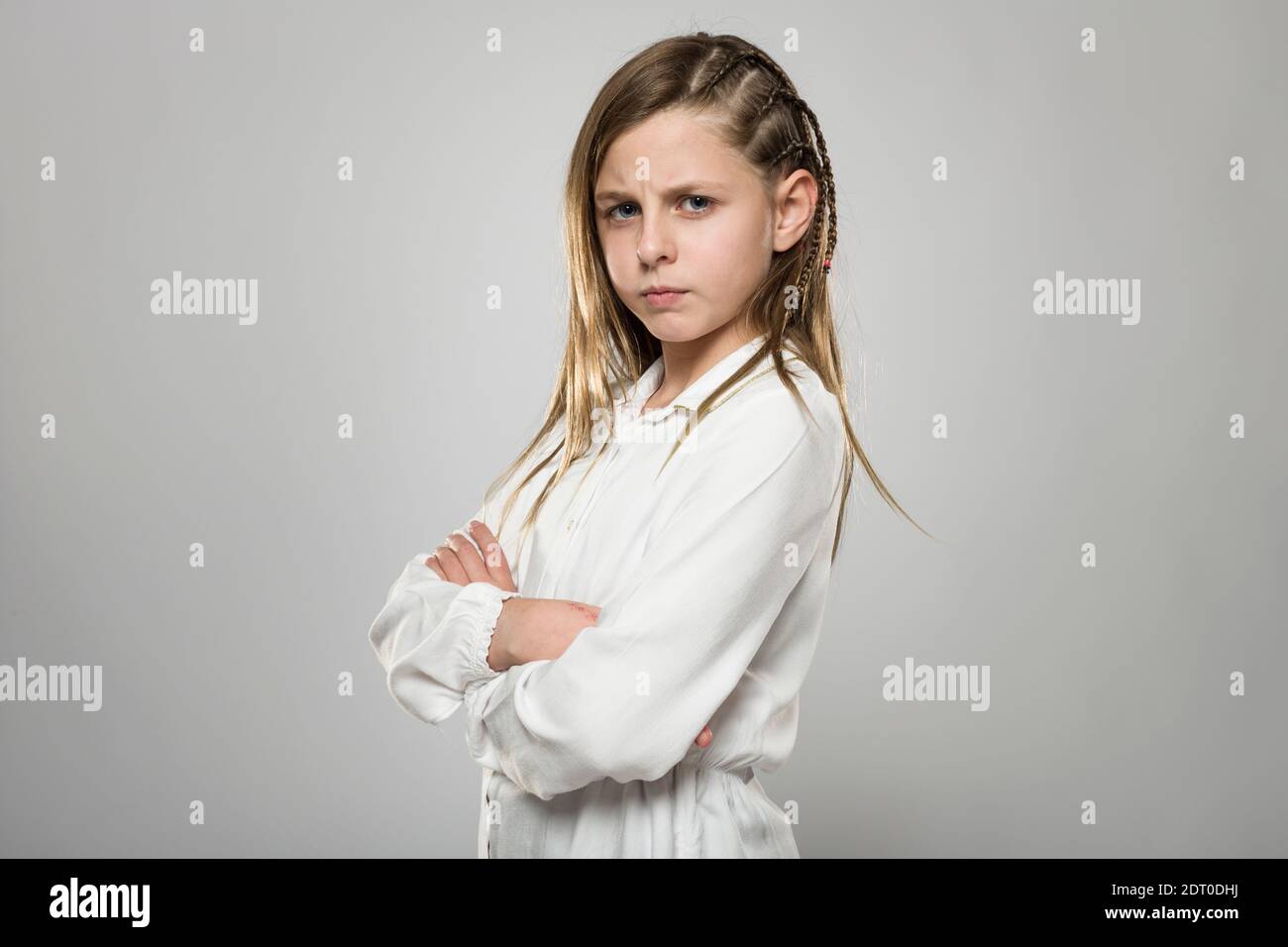Studio portrait of a cute angry girl with long blonde hair wearing a ...