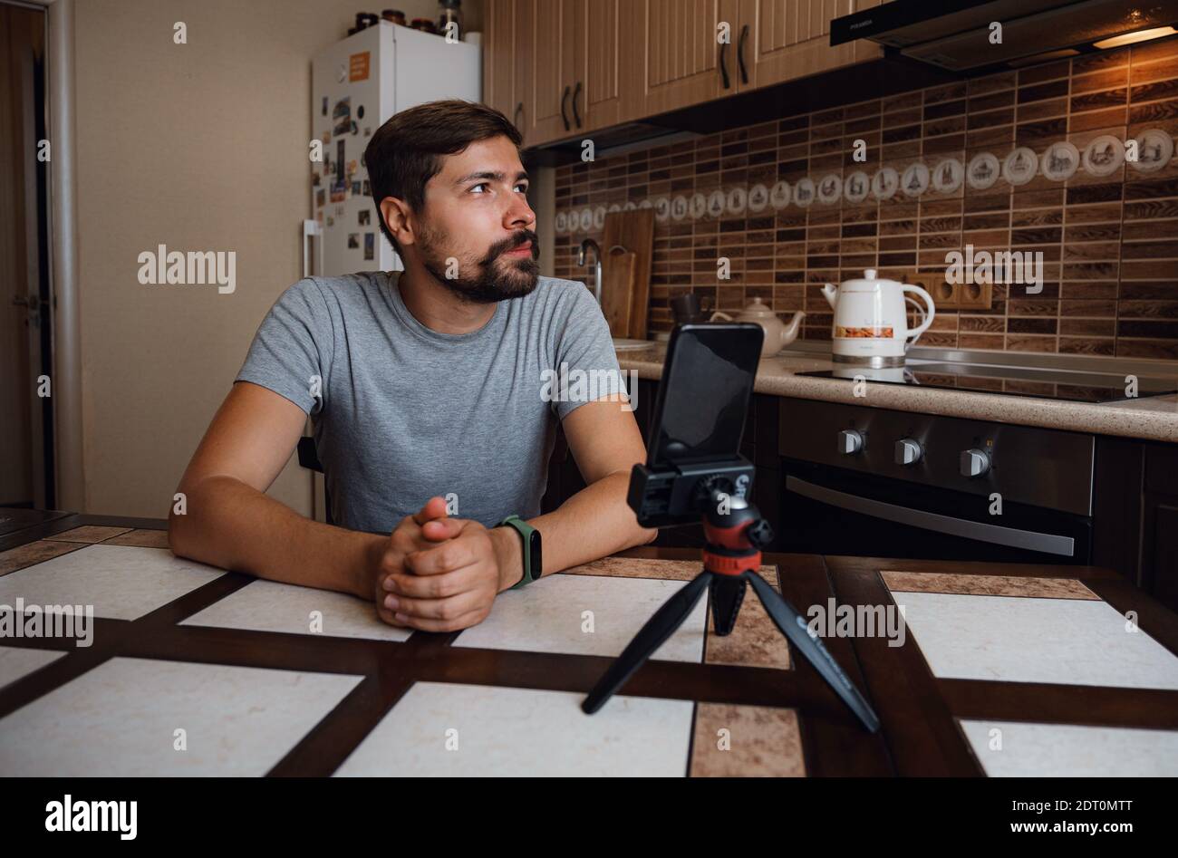 Young man having video call via smartphone in the home office. Virtual ...