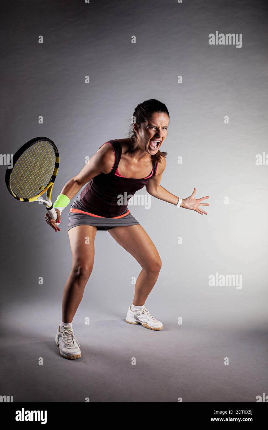 Professional female tennis player. Angry girl screaming with racket in ...