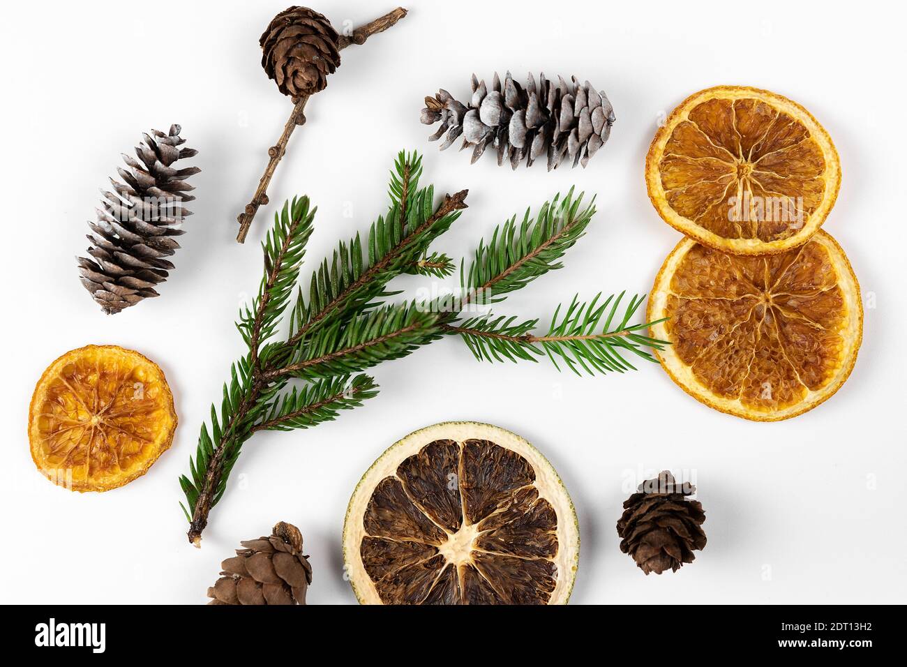 cones and spruce branches with dry slices of citrus on a white ...
