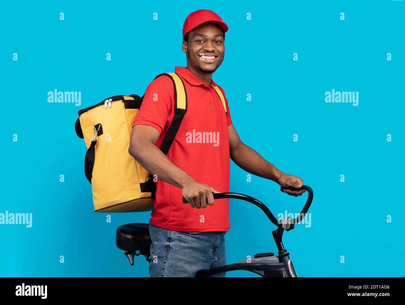 Smiling delivery delivery man riding bicycle at studio Stock Photo - Alamy