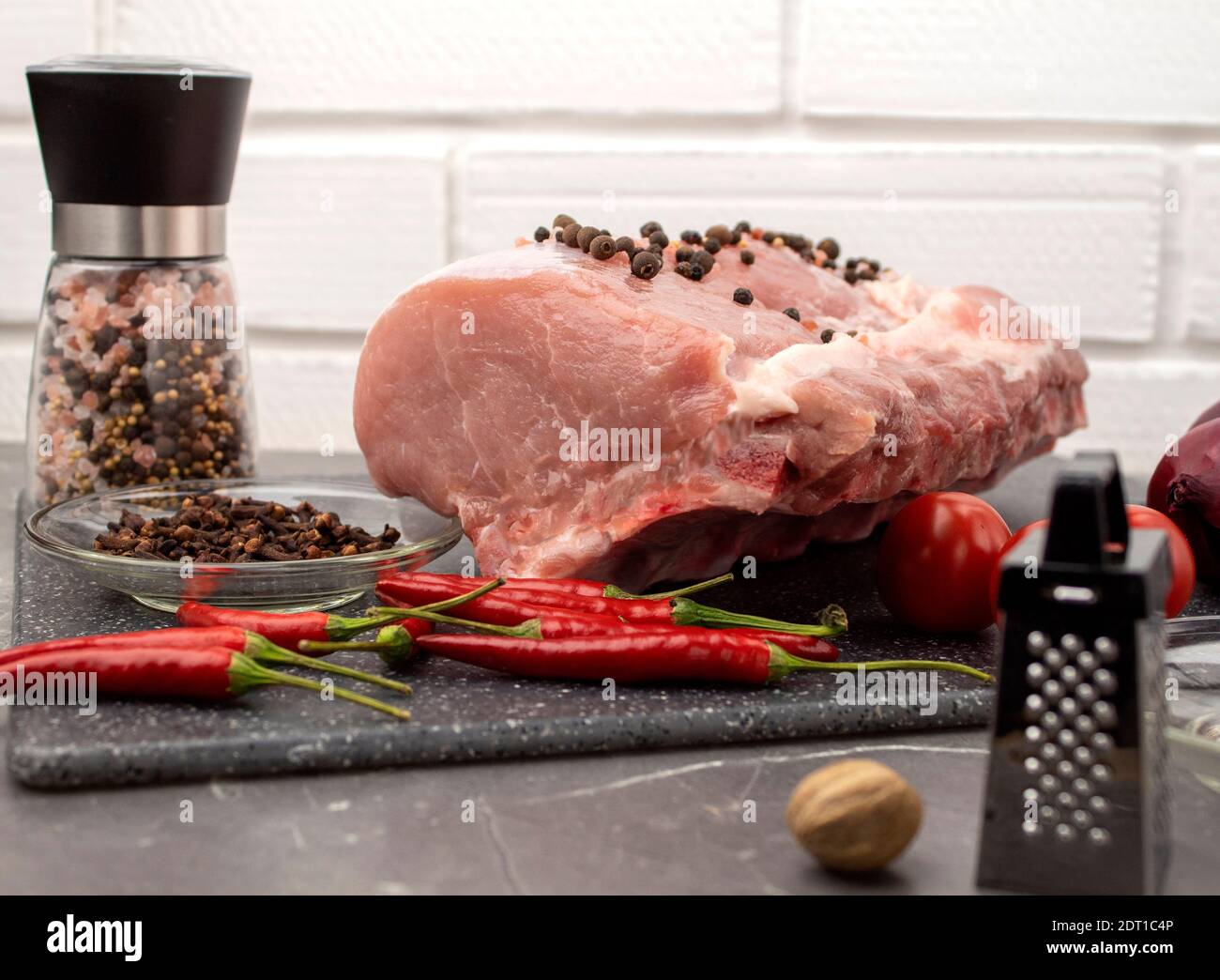 Raw pork meat on a marble board with spices and vegetables Stock Photo ...
