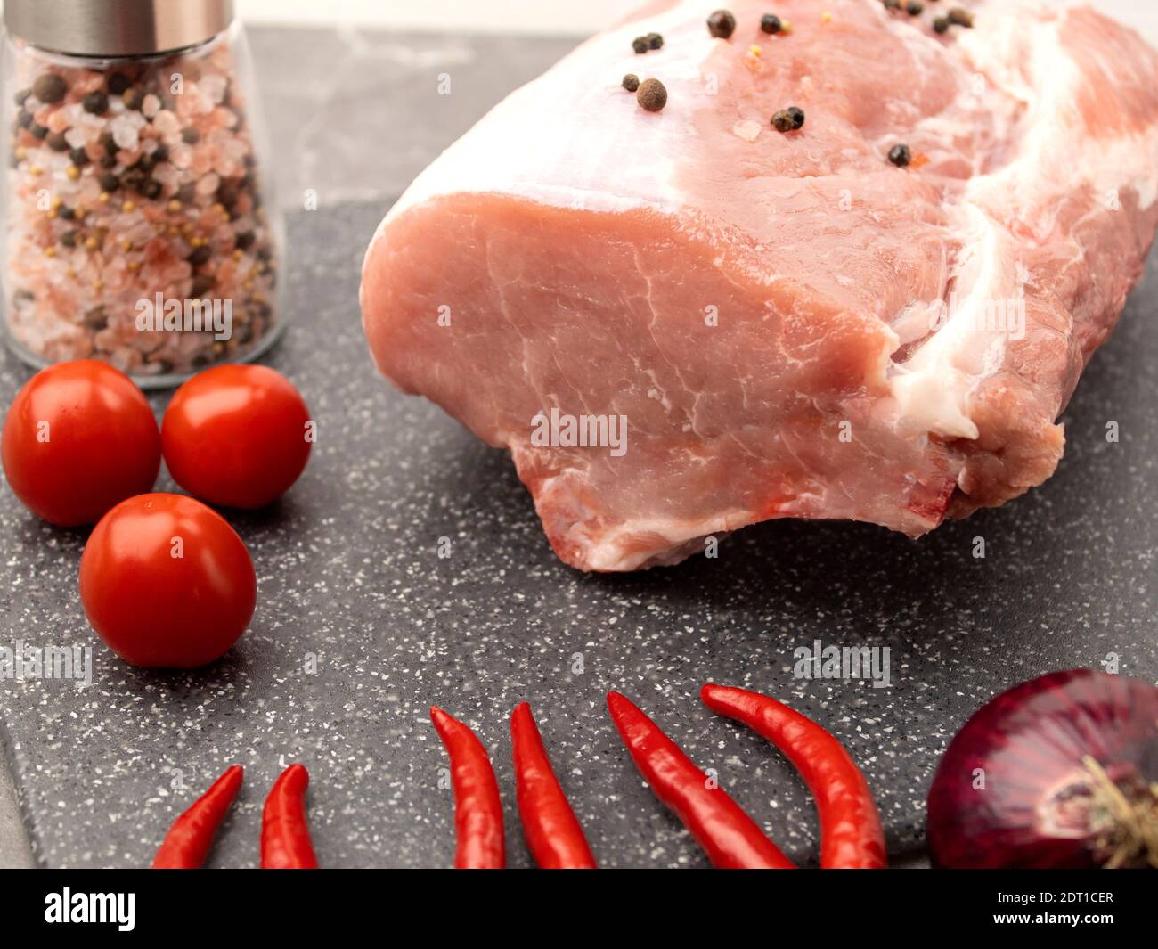 Raw pork meat on a marble board with spices and vegetables Stock Photo ...