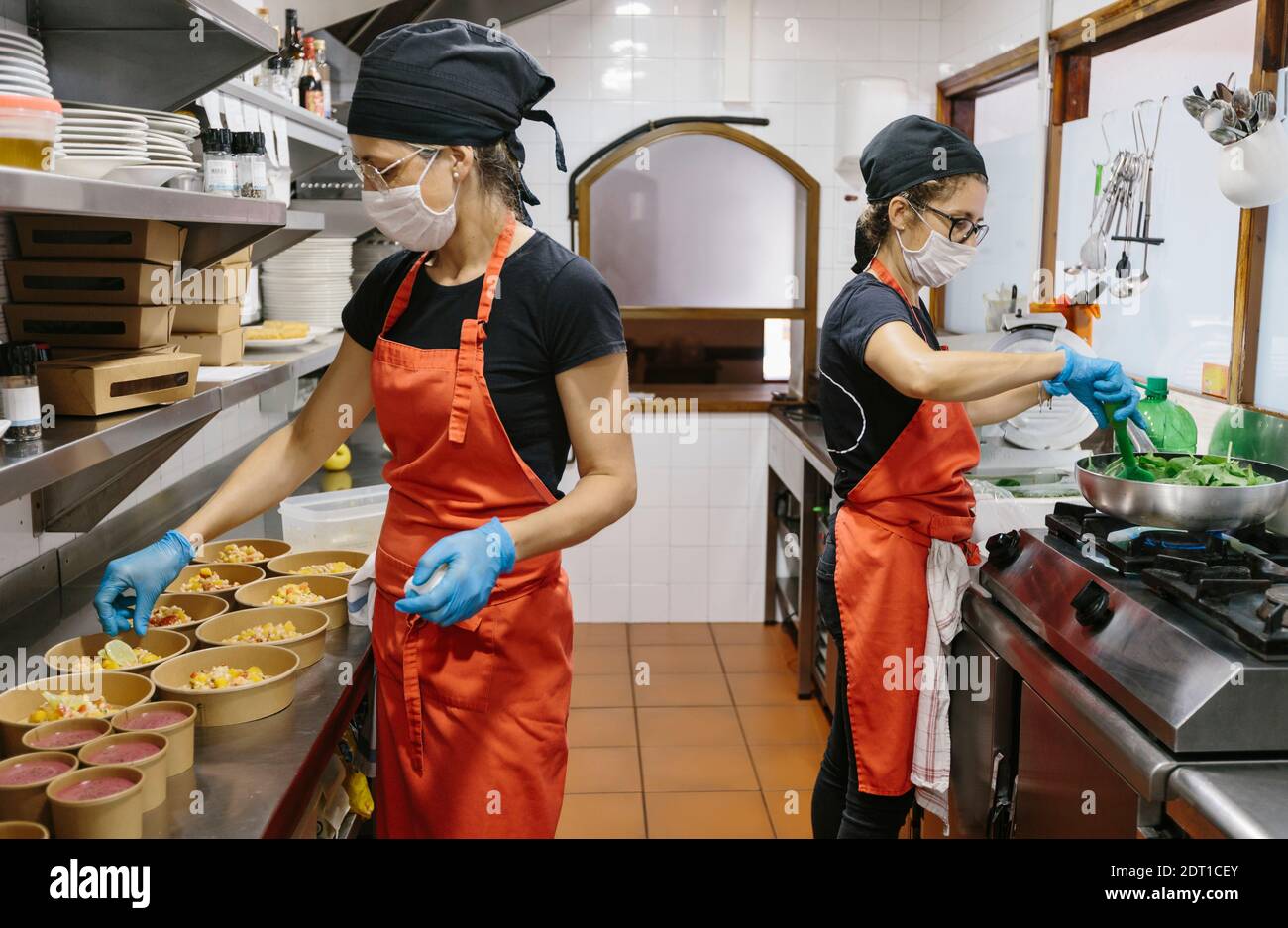 Cooks in a restaurant protected by a mask as a precaution against the ...