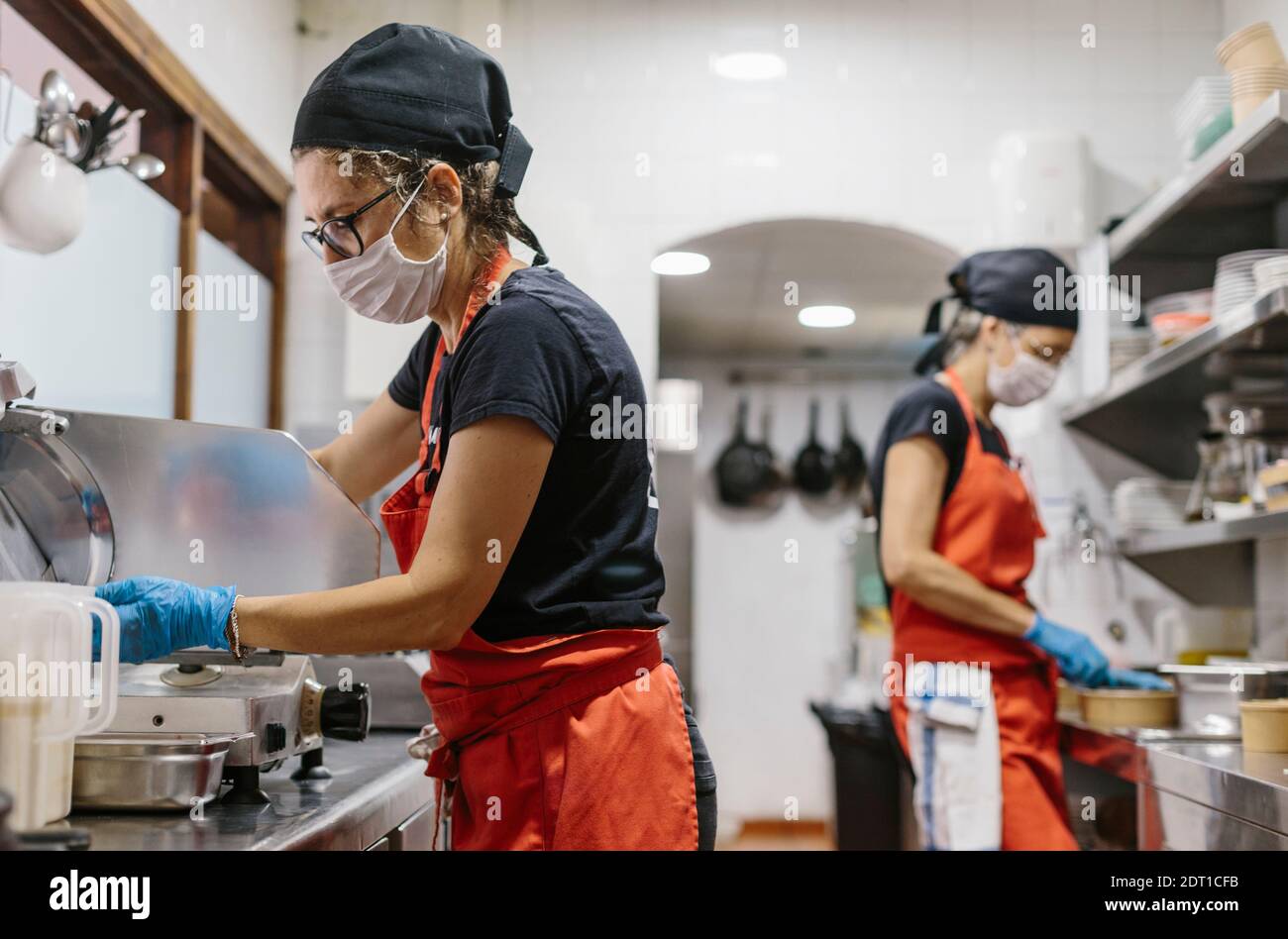 Cooks in a restaurant protected by a mask as a precaution against the ...