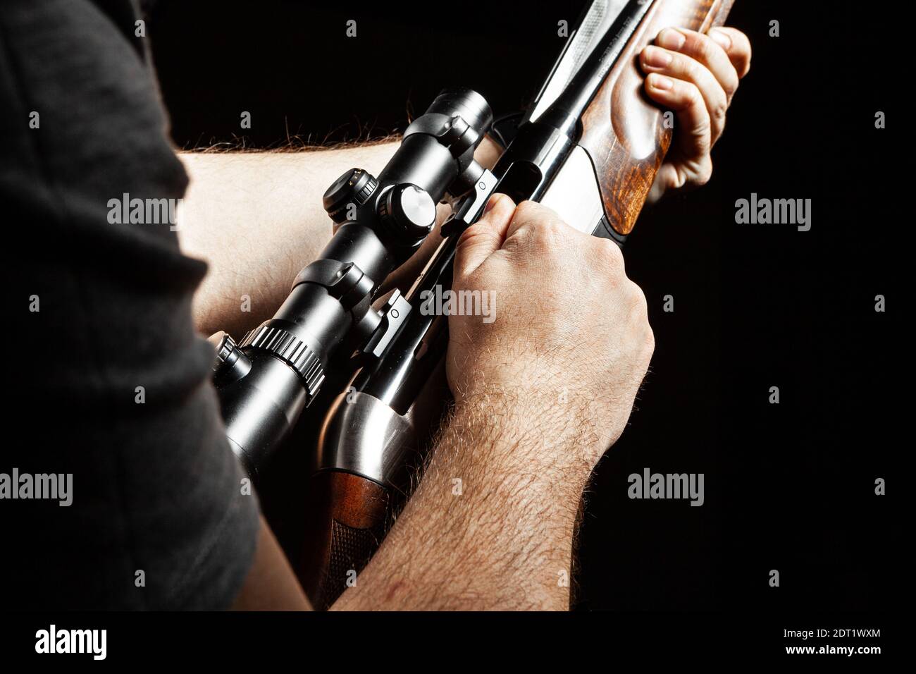 Male hands holding hunting rifle on black background Stock Photo - Alamy