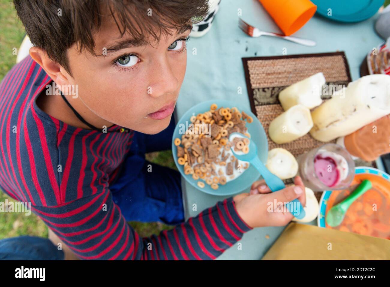 Boy having breakfast on camp site Stock Photo - Alamy
