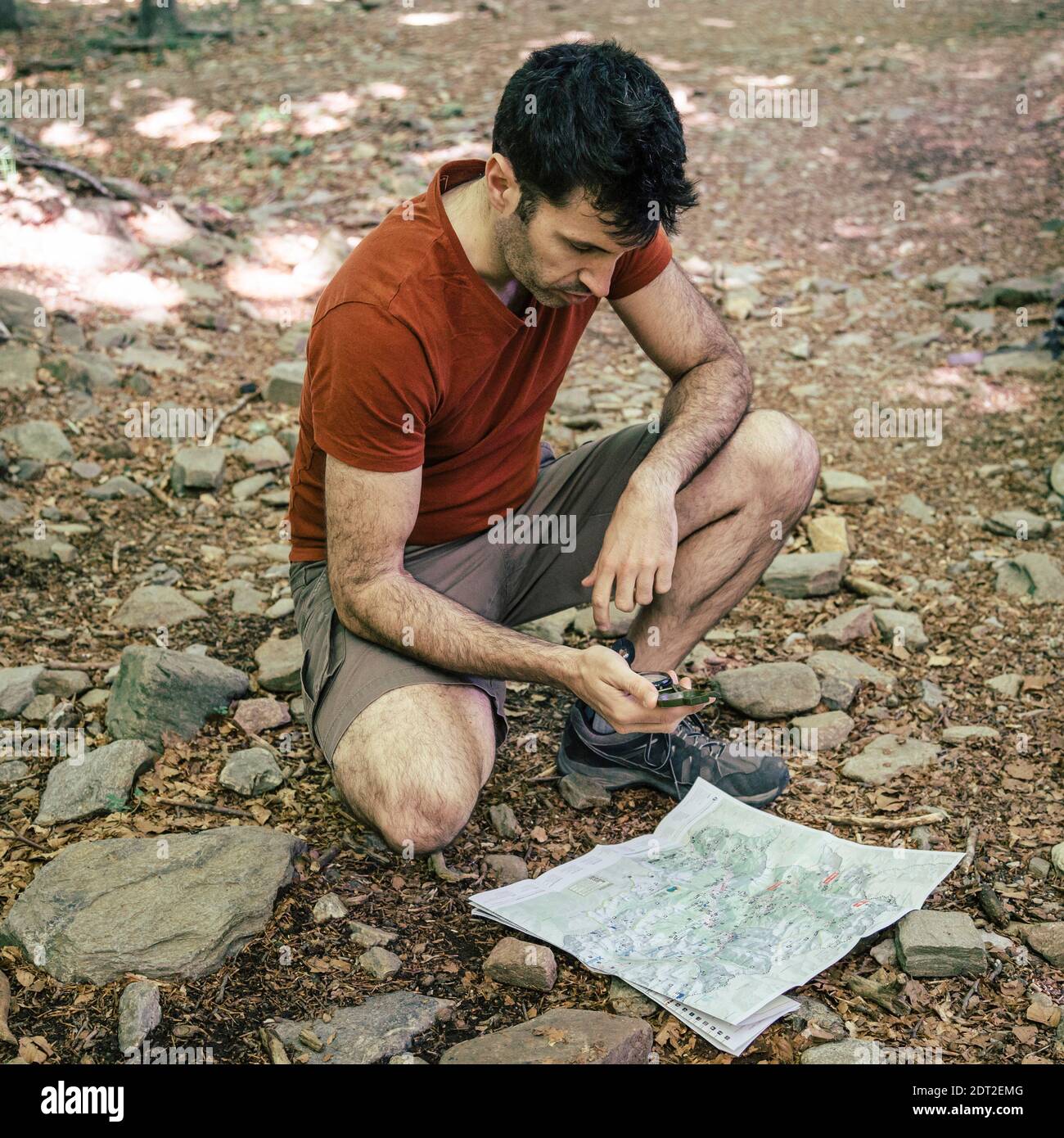 Hiker locating a path in the forest with a compass and map Stock Photo ...