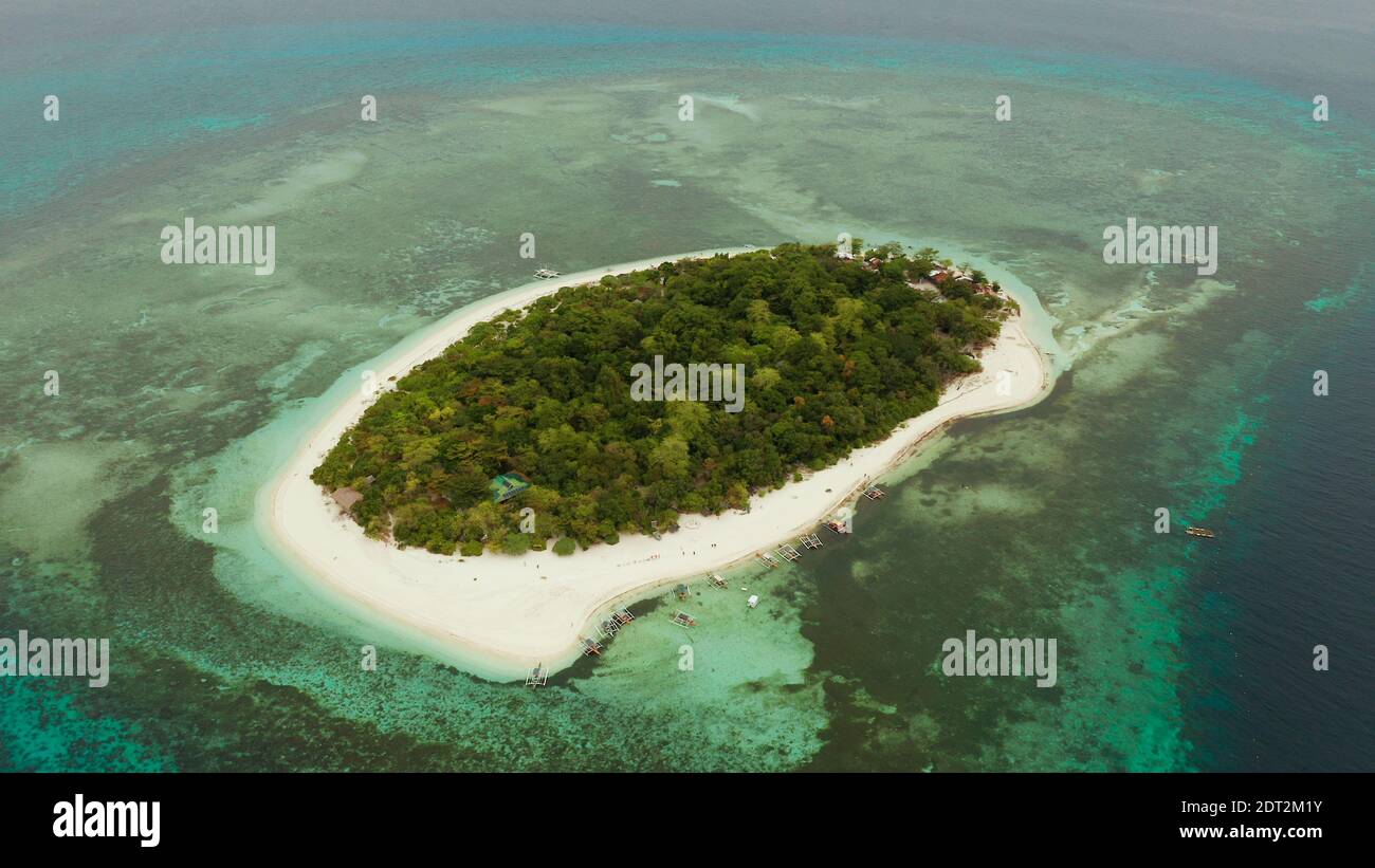 Small tropical island on an atoll with beautiful sandy beach surrounded ...