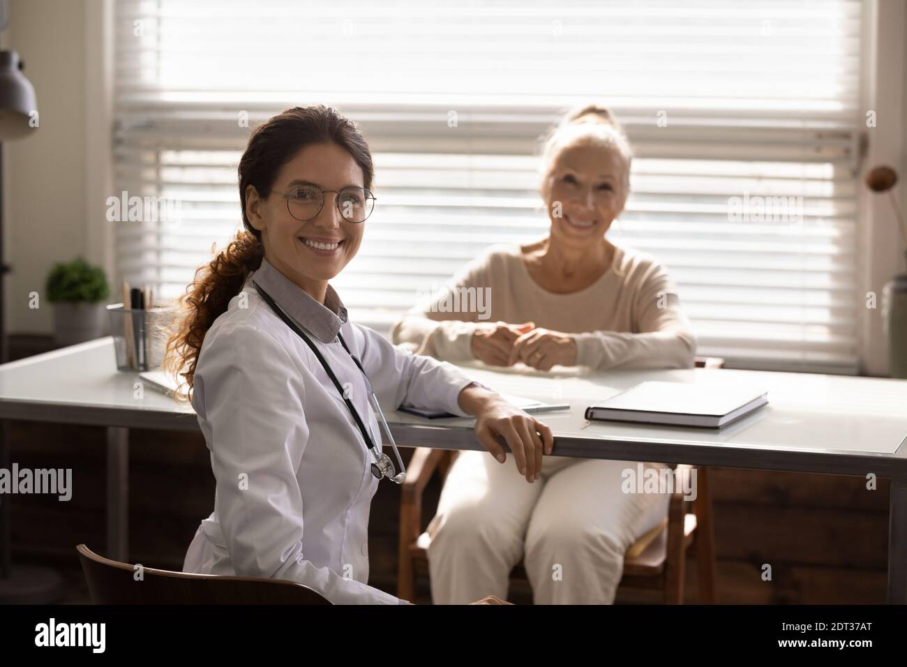 Portrait of female doctor at consultation with senior patient Stock ...
