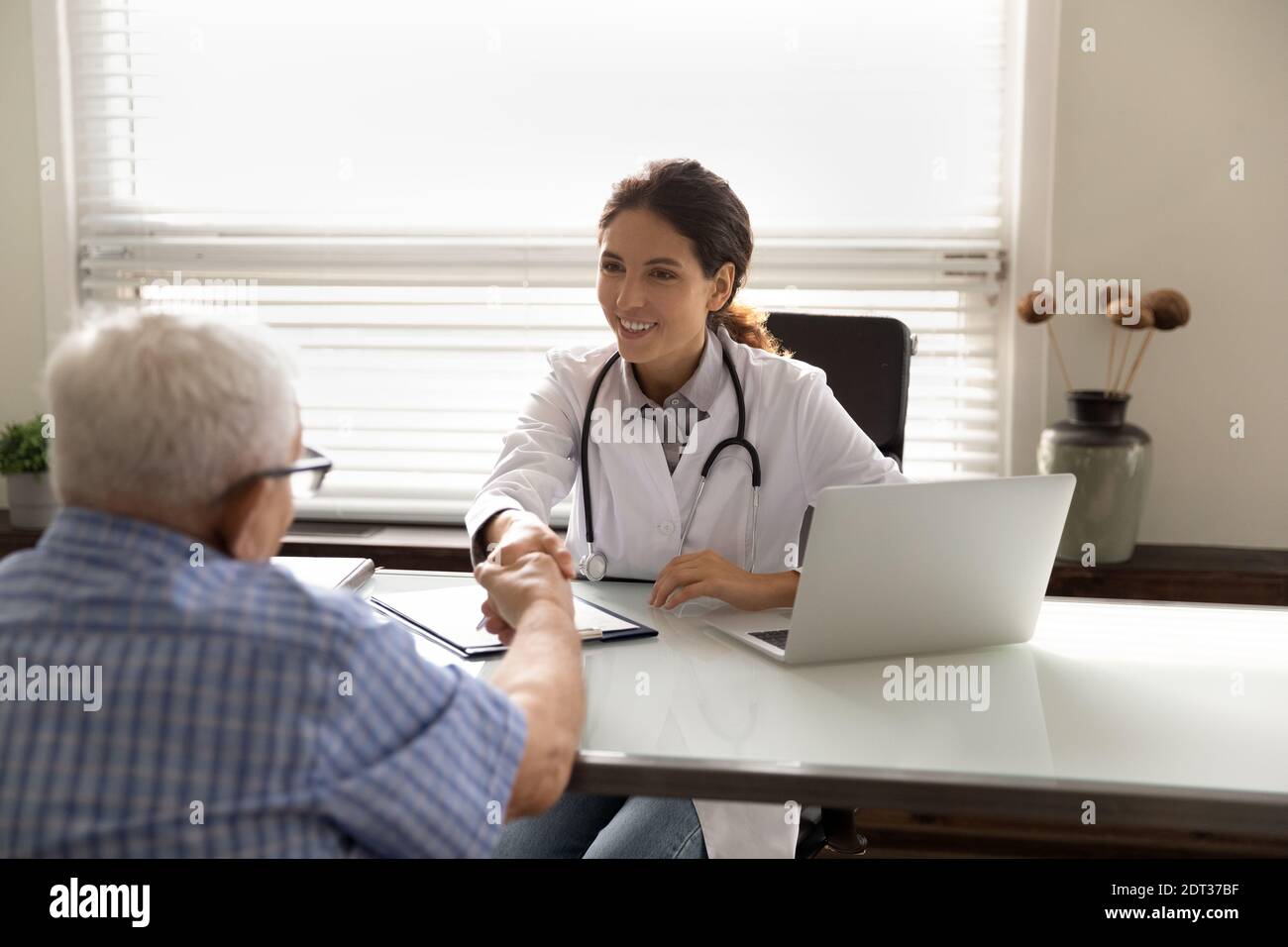 Smiling male doctor shake hand of male mature patient Stock Photo - Alamy