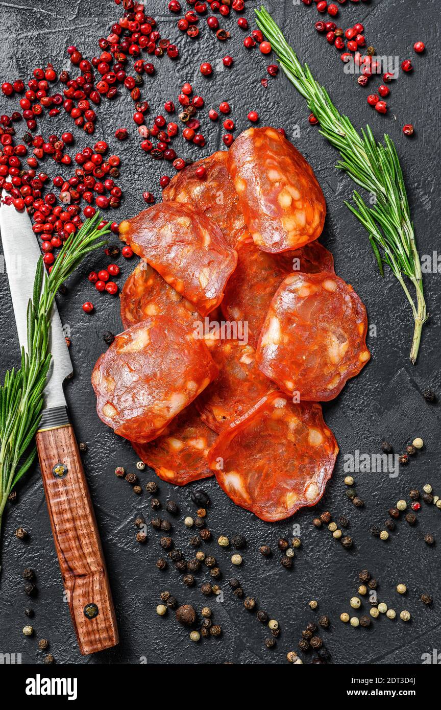 Spanish sliced chorizo sausage. cured meat. Black background. Top view ...