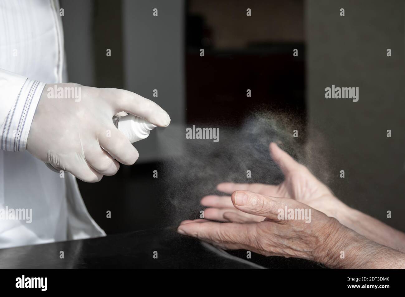 The coronavirus. The doctor gives a disinfectant gel on the hands of an ...