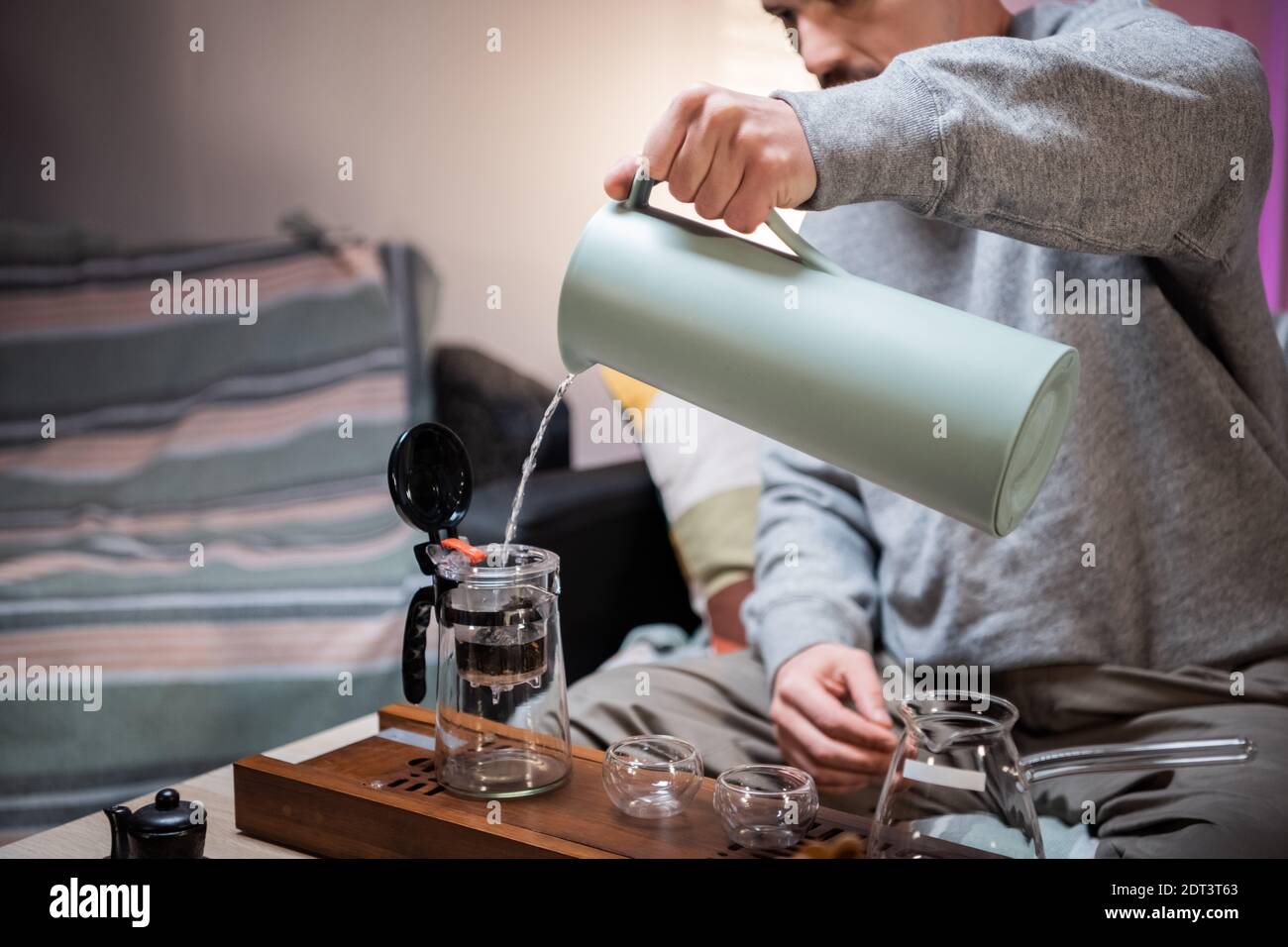 A man brews chinese tea according to an old oriental recipe on a bamboo ...