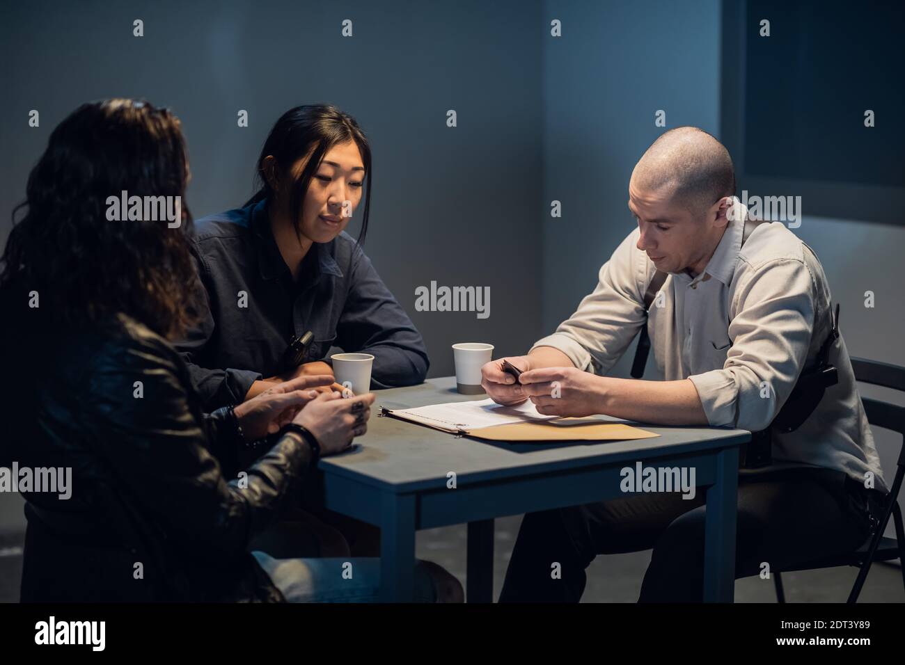 An experienced investigator and a female police officer interrogate the ...