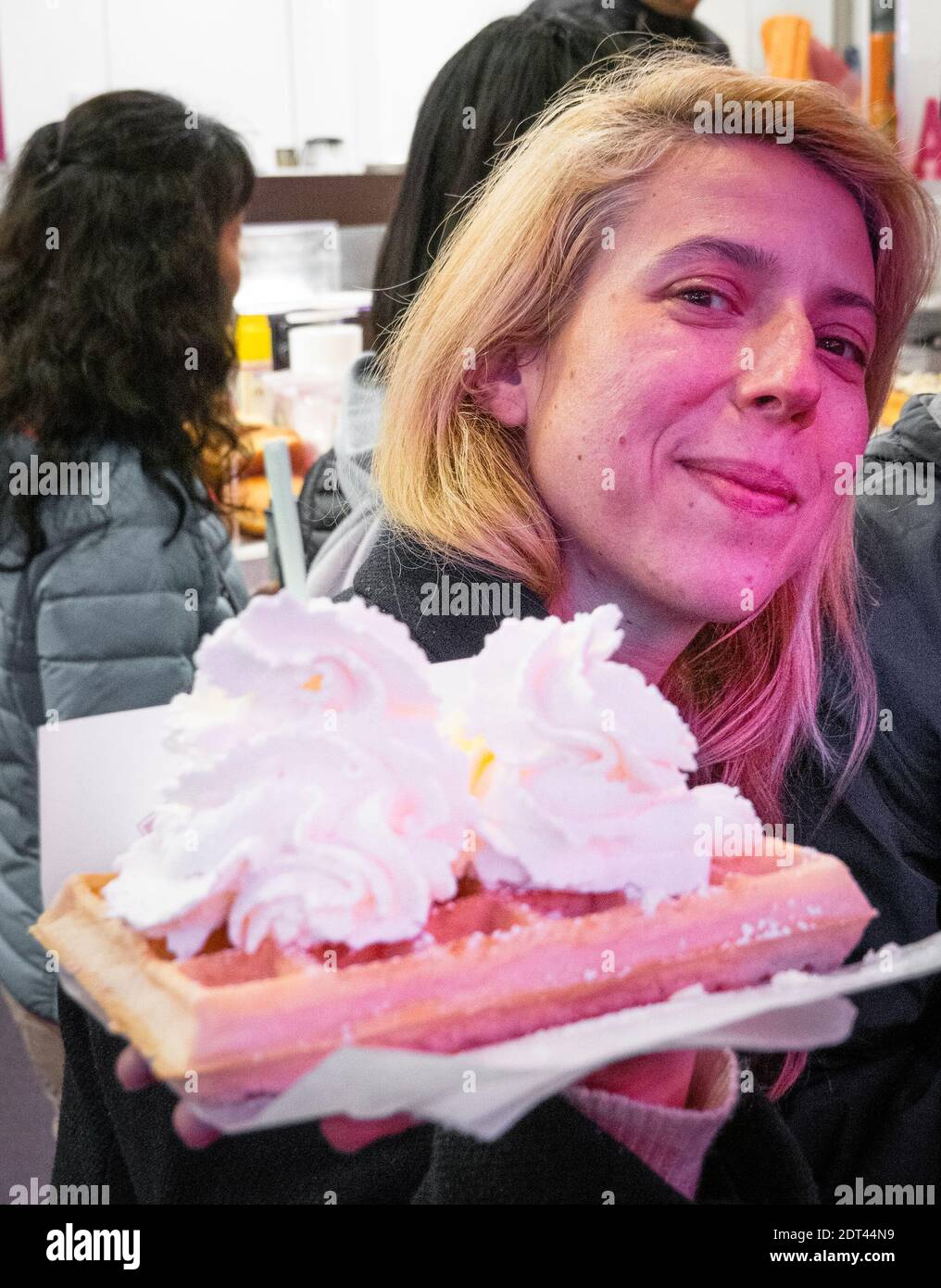 Smiling mid-adult woman showing waffle with whipped cream Stock Photo ...